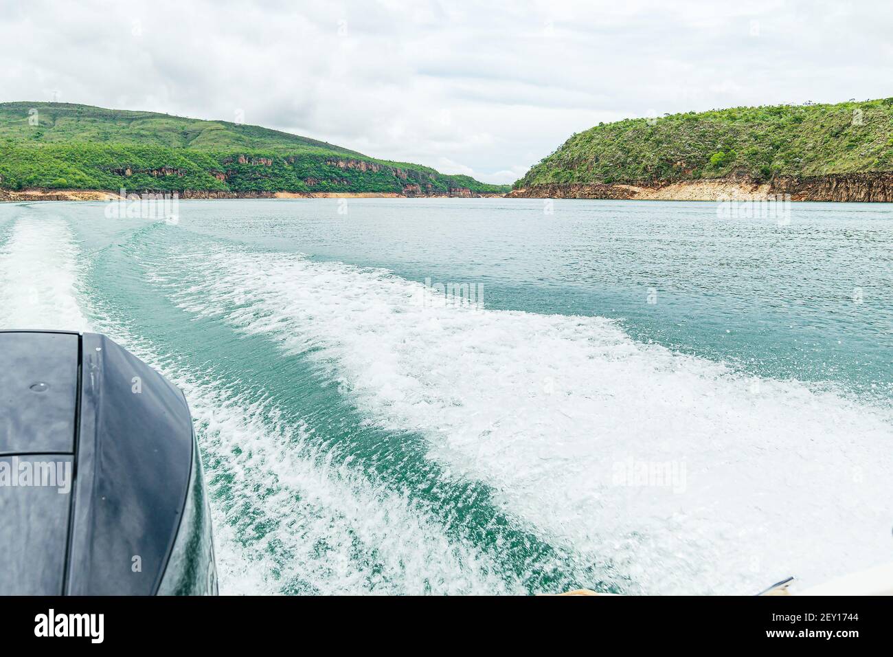 Rear view of a speedboat ride on the lake making waves and the ...