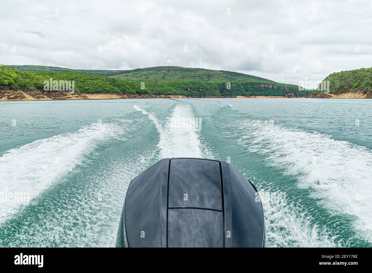 Rear view of a speedboat ride on the lake making waves and the ...