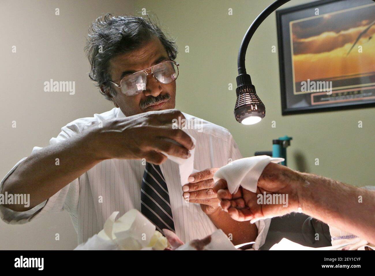 Dr. Subbarao Polineni works on a patient's hand at his St. Peters, Mo ...