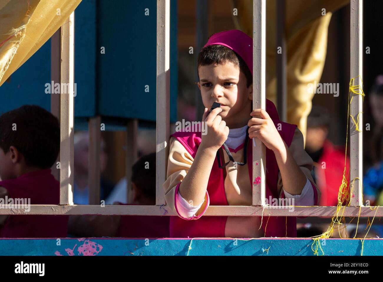 Portrait of a young boy holding a whistle to his lips from a float ...