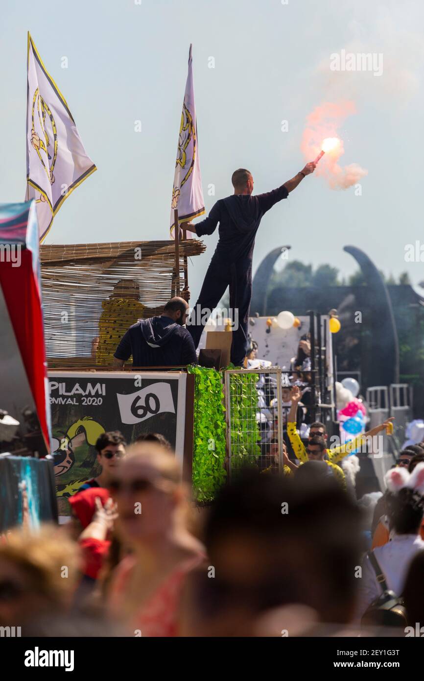 A man holding up a flare from a float during the Carnival in Limassol ...
