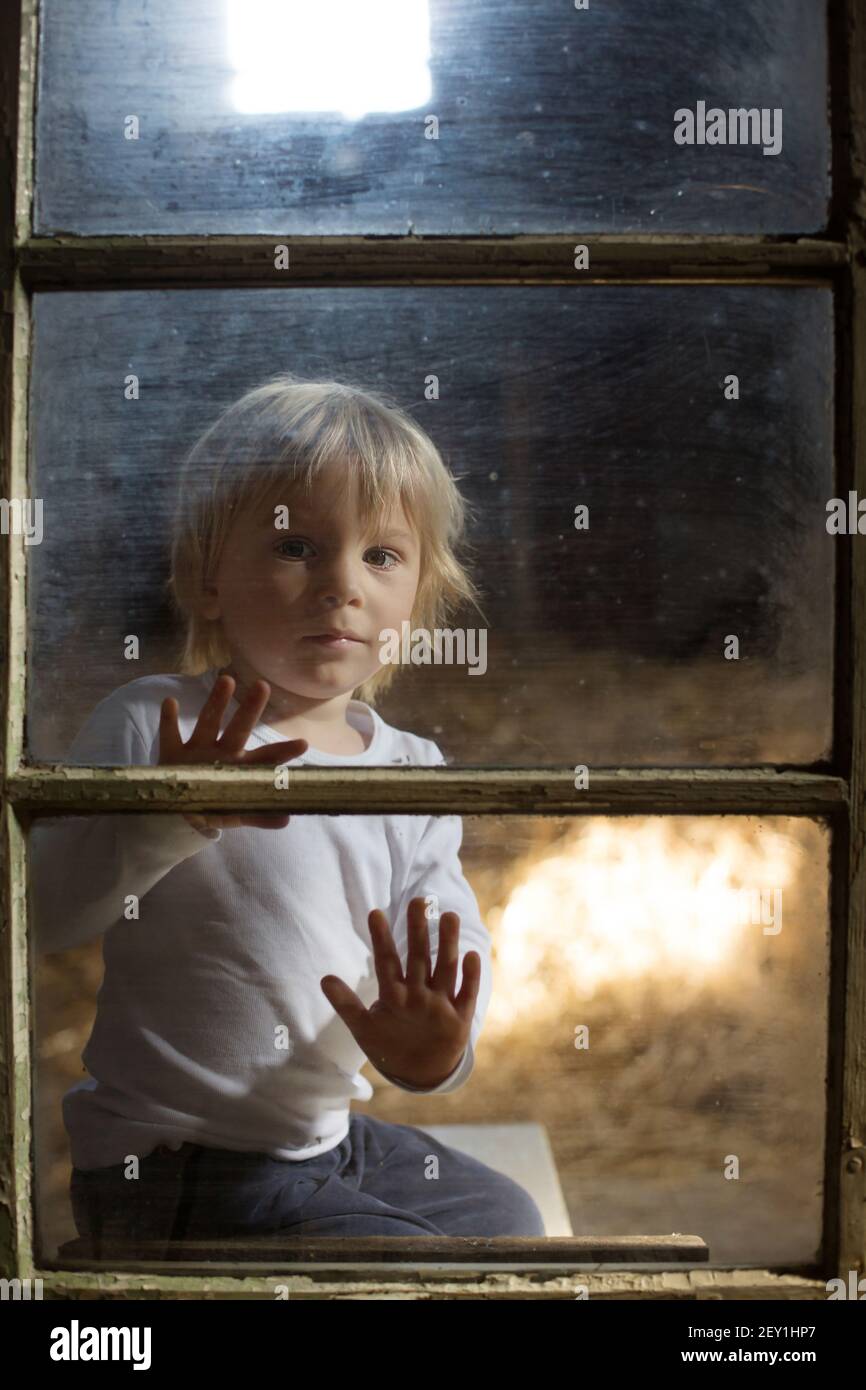 Blond child behind the window, looking outside at the moon Stock Photo ...