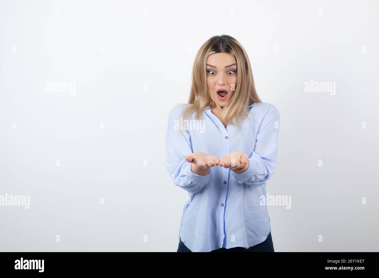 Image of young pretty woman standing and looking at her hands Stock ...