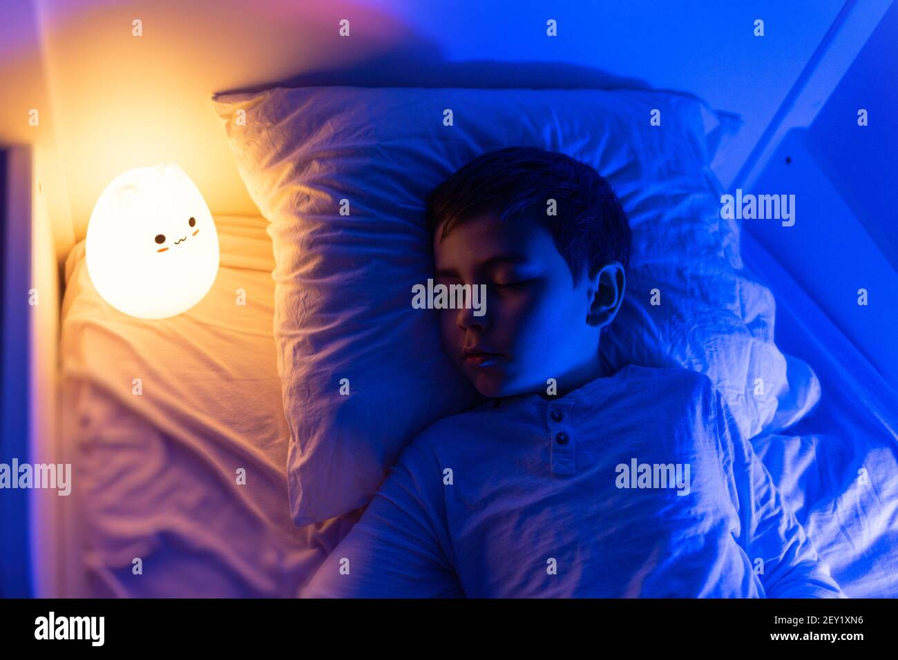 six years old bouy sleep with LED night lamp, School child dreaming ...