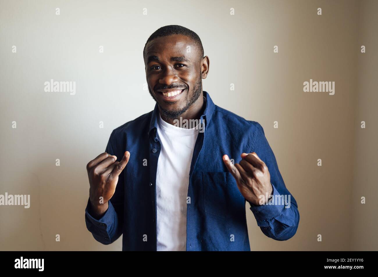 A closeup shot of a smiling black male showing hand gestures ...