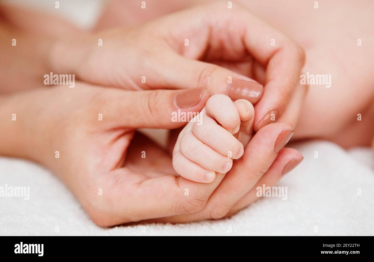 Baby holding mother finger Stock Photo - Alamy