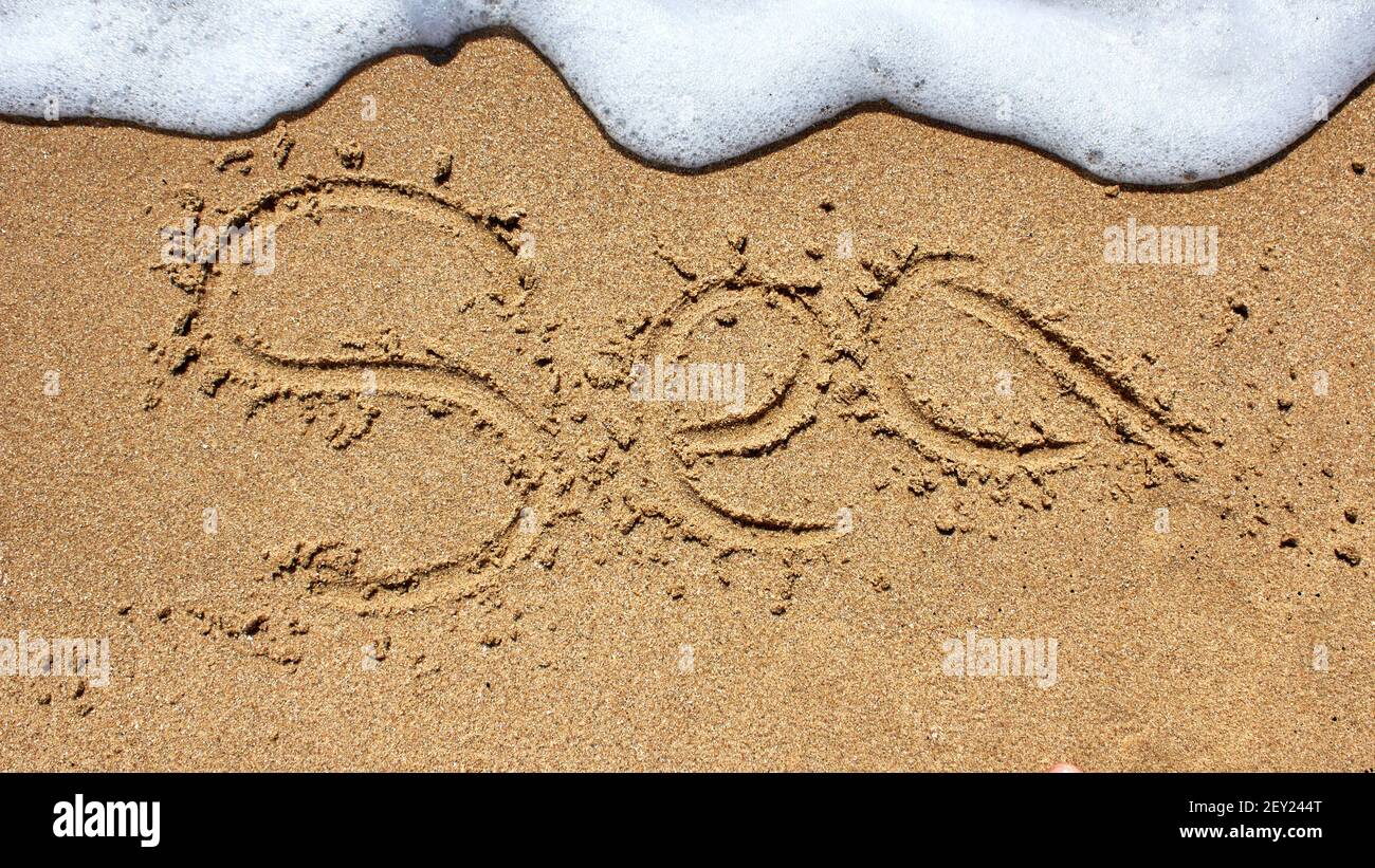 Sea word written on beach sand Stock Photo - Alamy