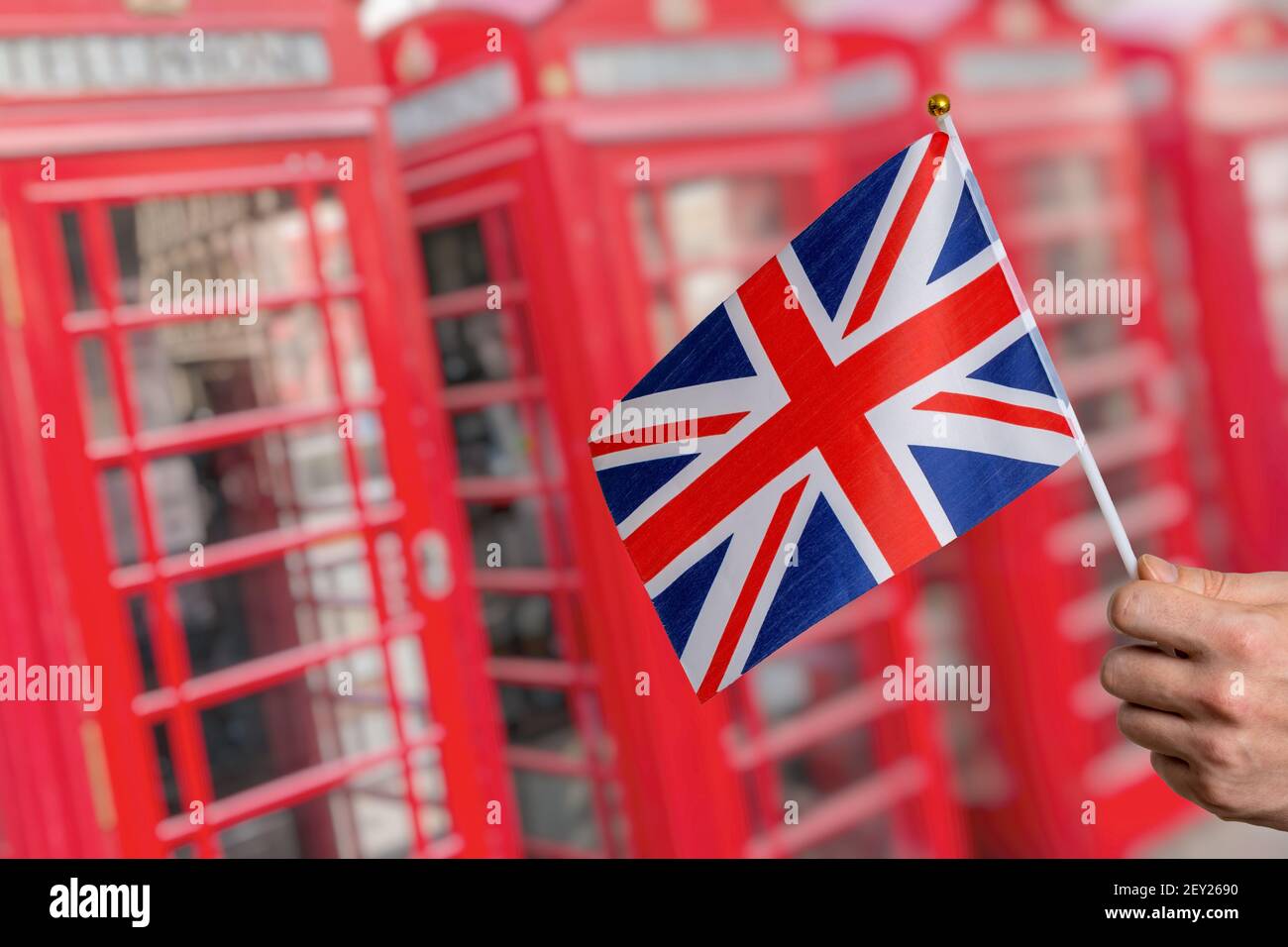 Flag of Great Britain and many London red phone booths in background ...