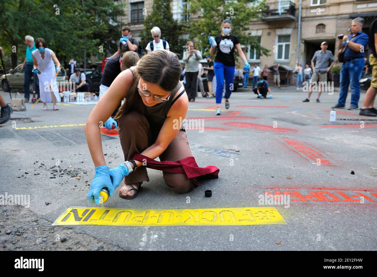 Young girl activist holding spray can painting offensive lettering ...