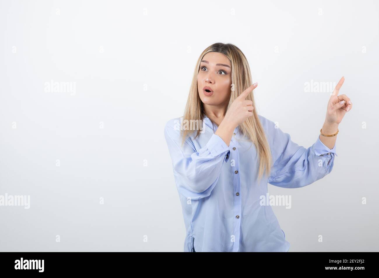 Image of young beautiful woman looking at something on white background ...