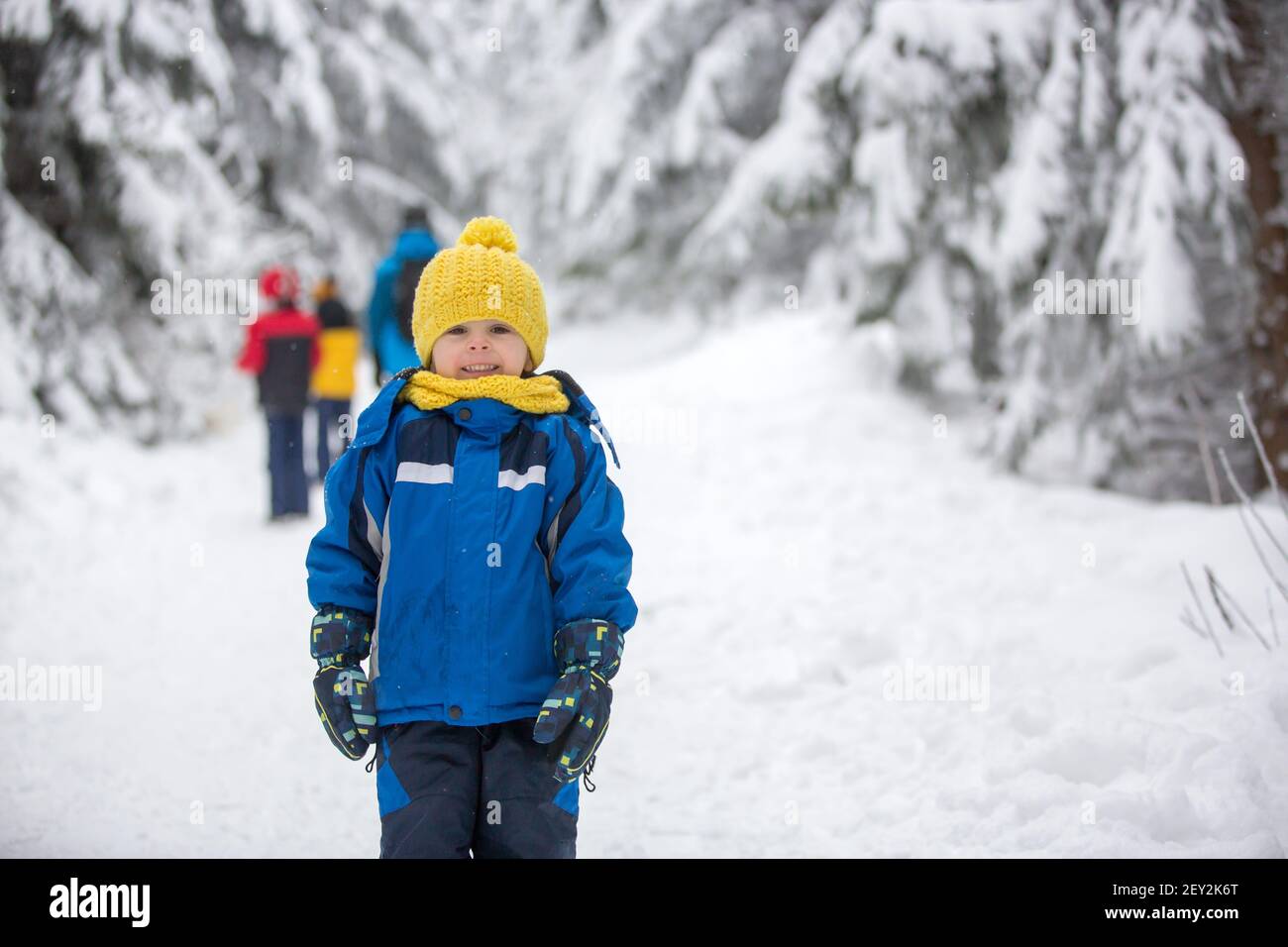 Sweet happy children, brothers, playing in deep snow in forest, frosted ...
