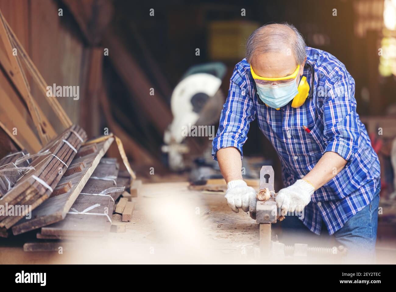 Carpenter, Senior man sanding wooden fence in workplace using work tool ...