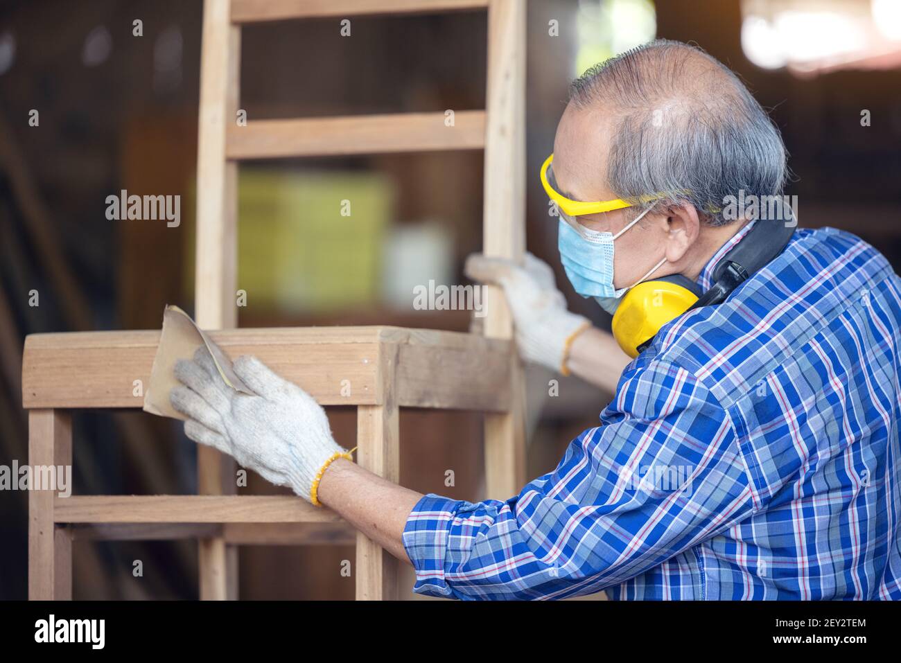 Carpenter, Senior man sanding wooden fence in workplace using work tool ...