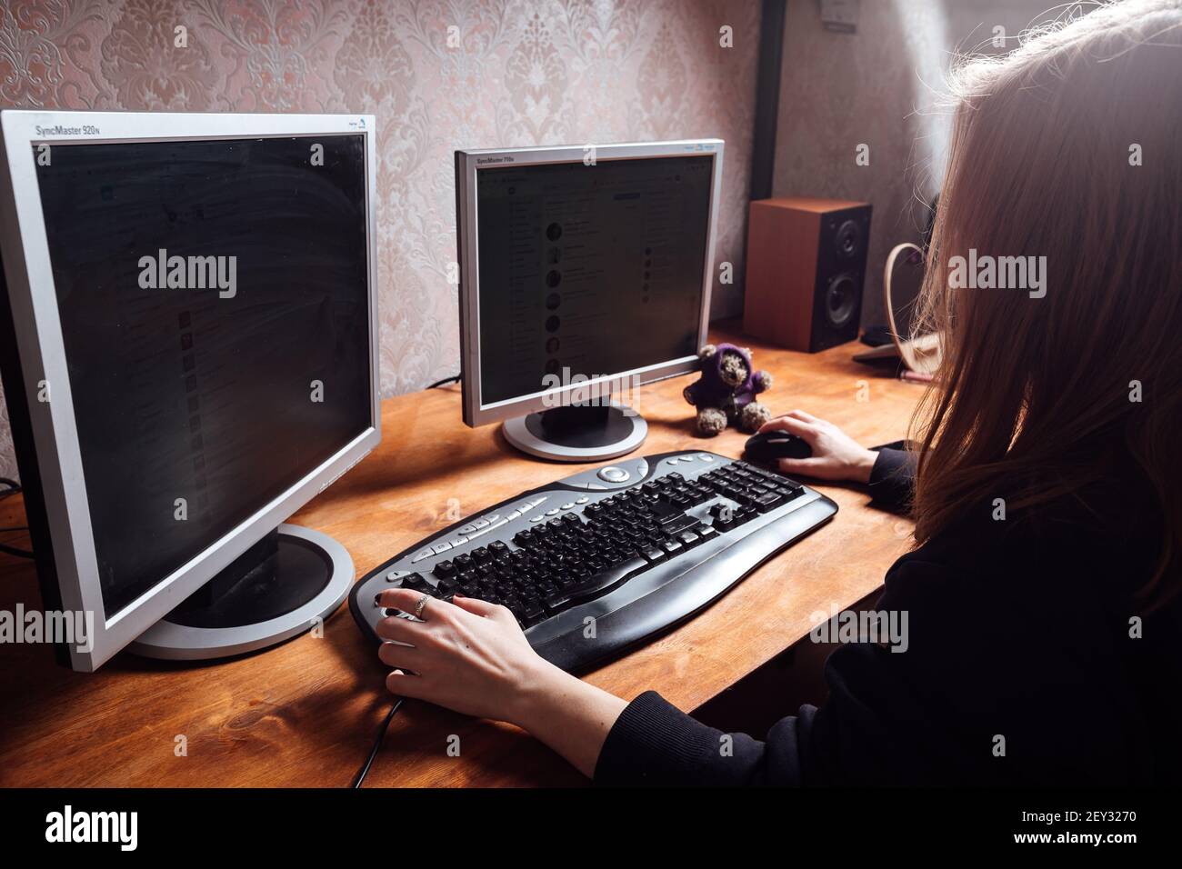 a girl is typing on a keyboard, working at a personal computer from ...
