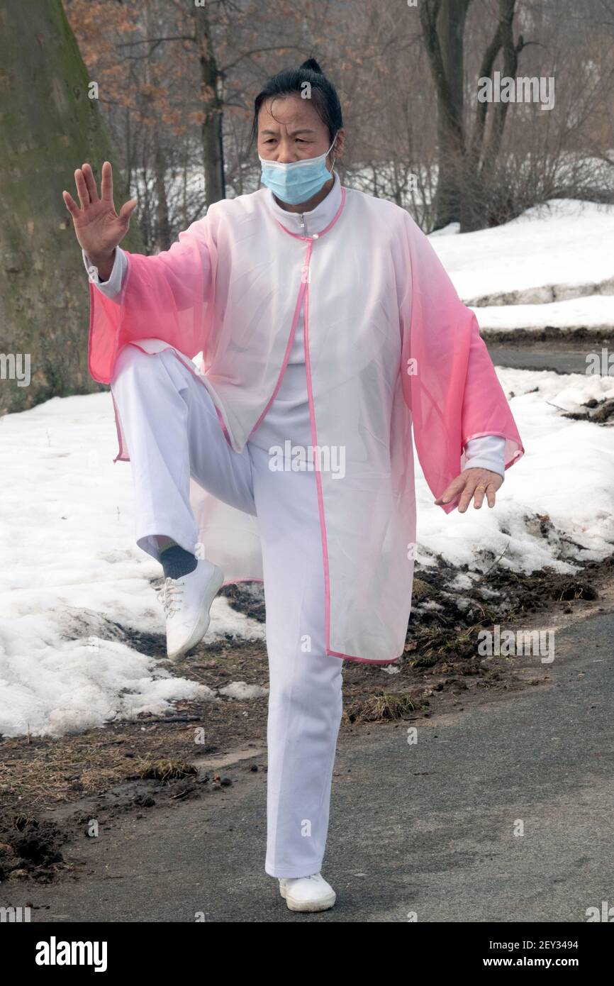A middle aged Chinese American woman gracefully does Tai Chi dance ...
