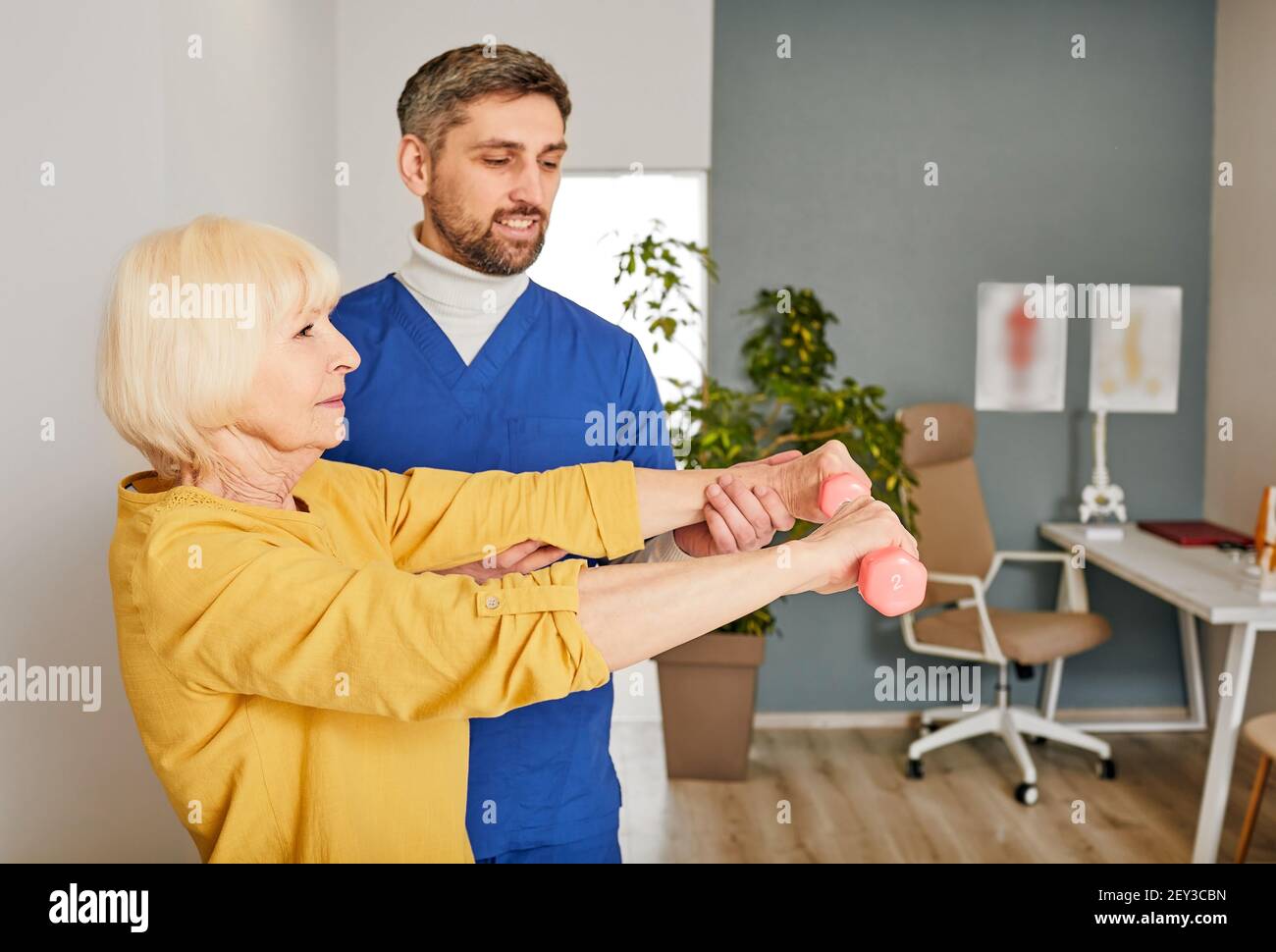 doctor using dumbbells to restore a senior woman's hands after trauma ...