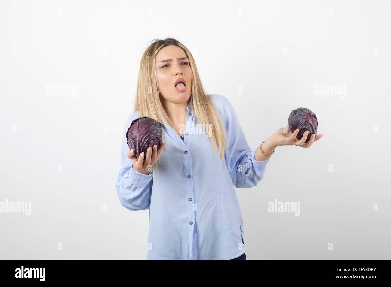 Beautiful woman in blue outfit holding purple cabbage and wants to ...