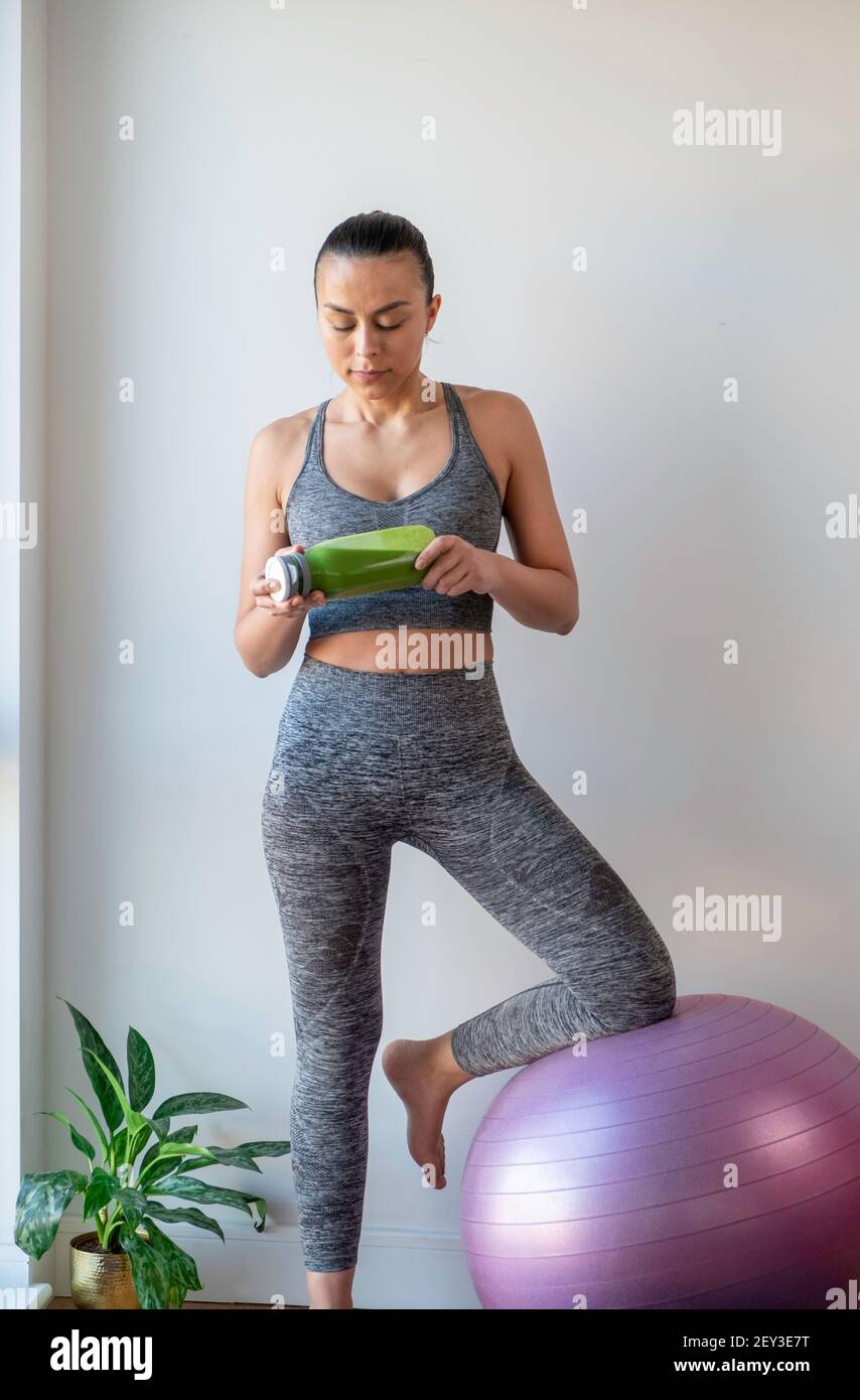 attractive woman shaking her green smoothie Stock Photo - Alamy
