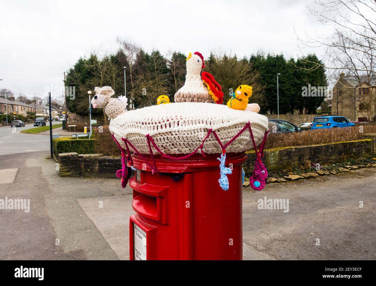 Knitted animal cover on a red post box.England, UK Stock Photo - Alamy