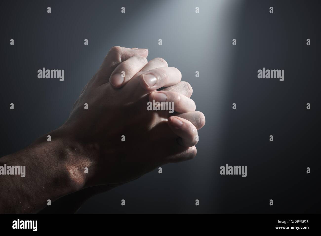 Hands of a prayer. Light shining on praying man's hands Stock Photo - Alamy
