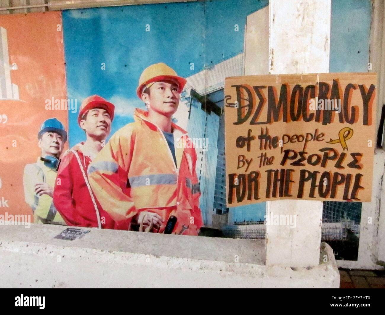 A protest sign hangs in juxtaposition with a Hong Kong government ...