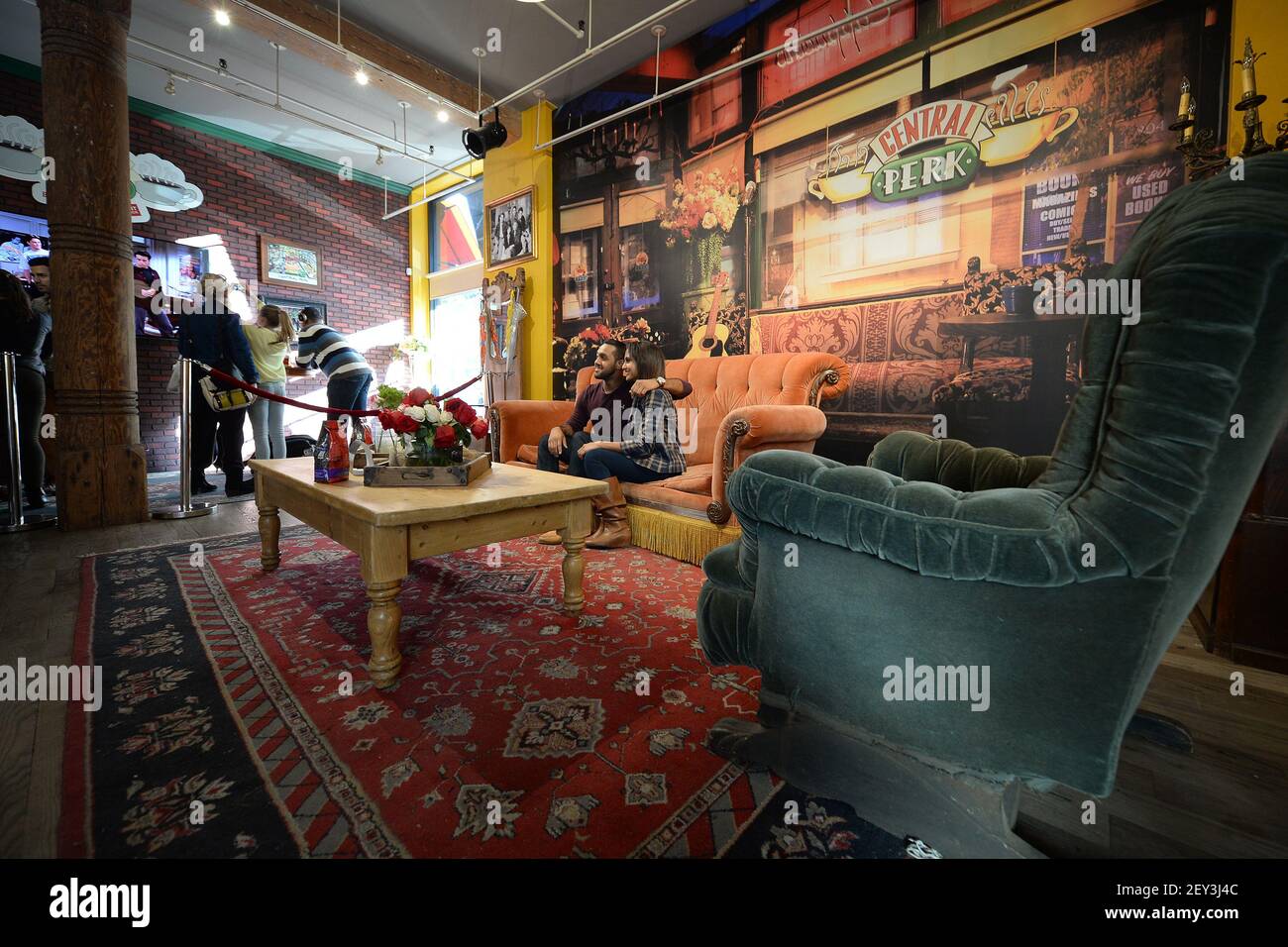 A couple pose on a replica of the couch and set of Warner Bros. TV ...