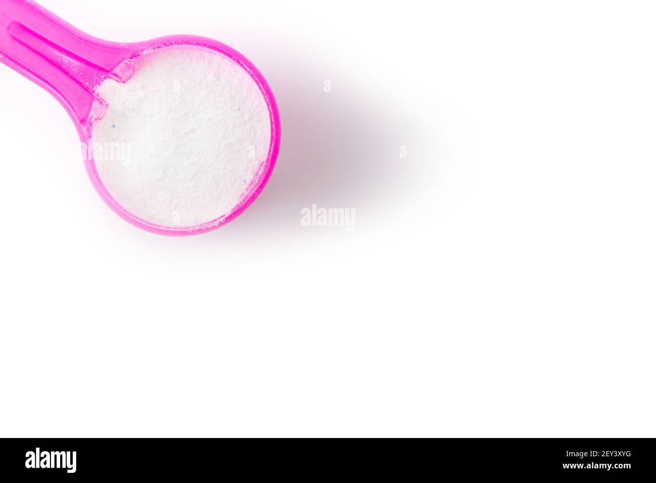top view of washing powder in pink measuring spoon isolated on white ...