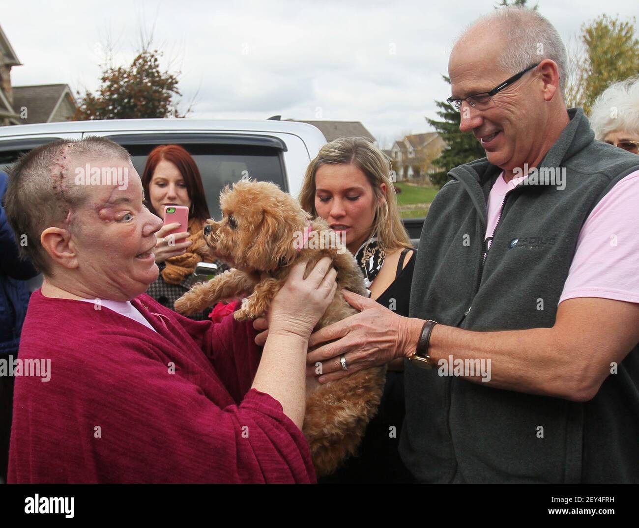 Sharon Budd takes her dog, Coco, from her husband Randy during a ...