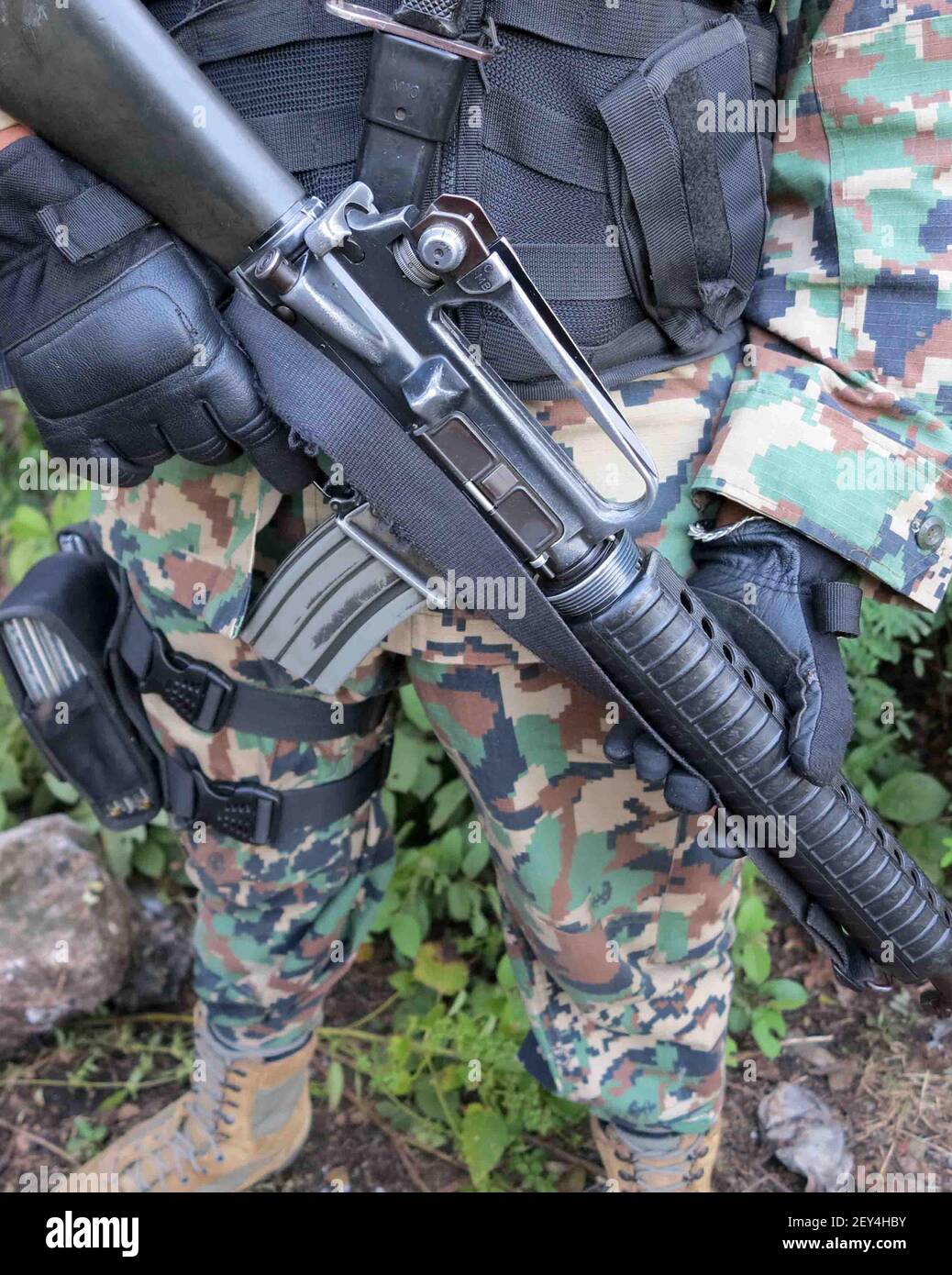 A Mexican naval commando holds his assault weapon near a hillside ...