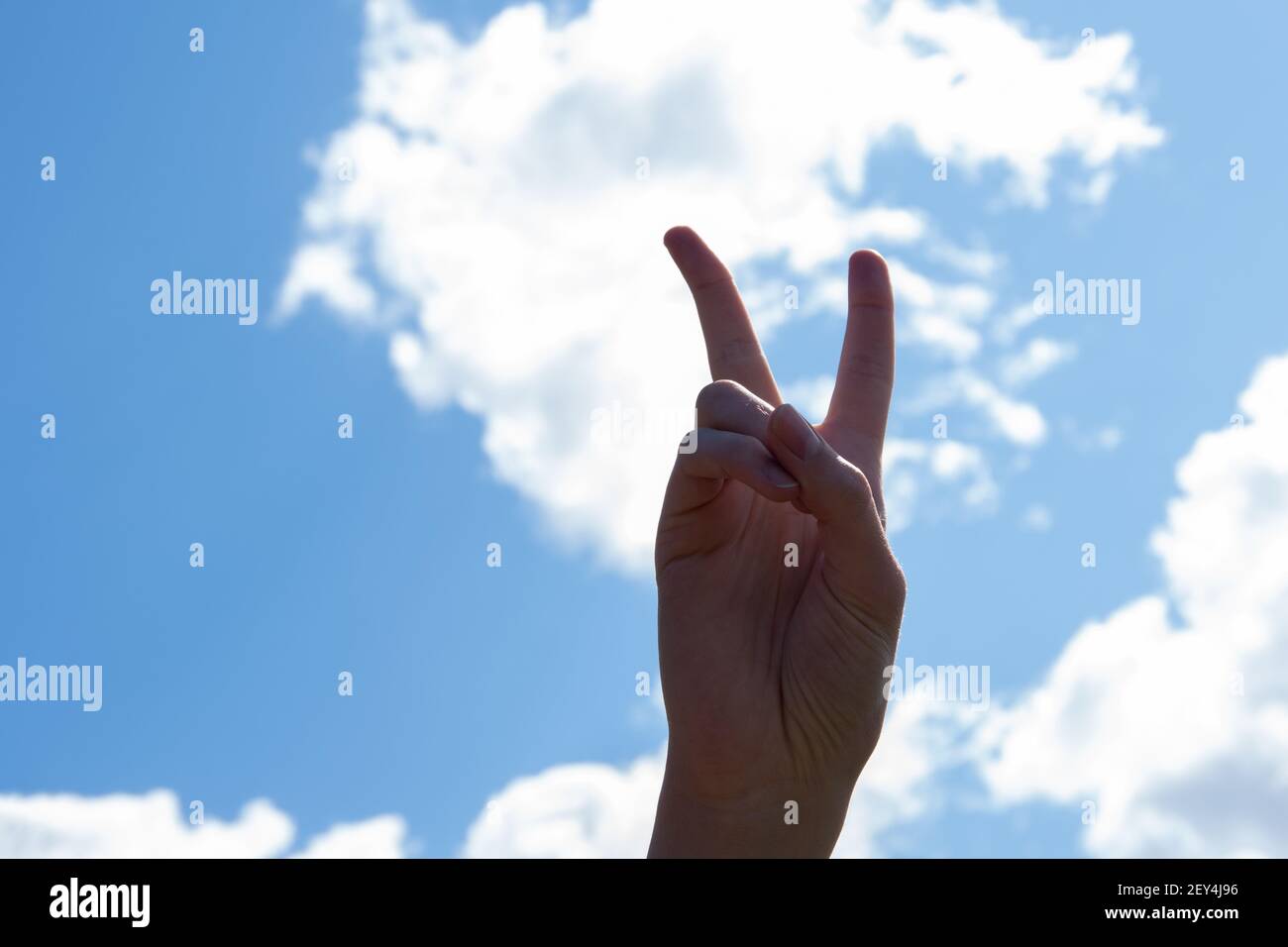 Hand with two fingers up in the symbol of peace or victory, a sign for ...