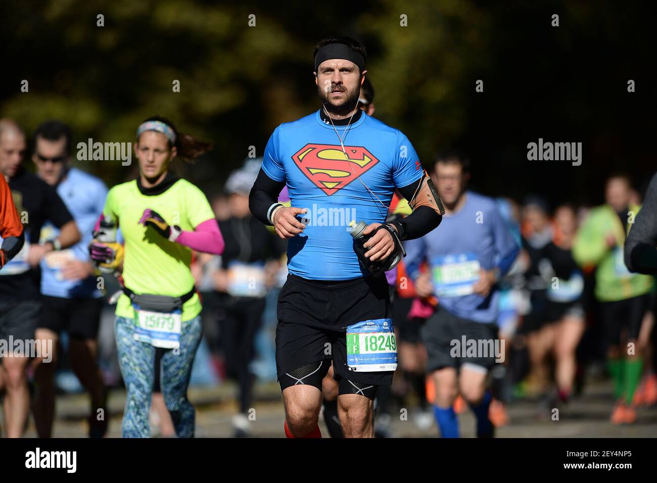 A runner wearing a Superman jersey makes his way towards the turn onto ...