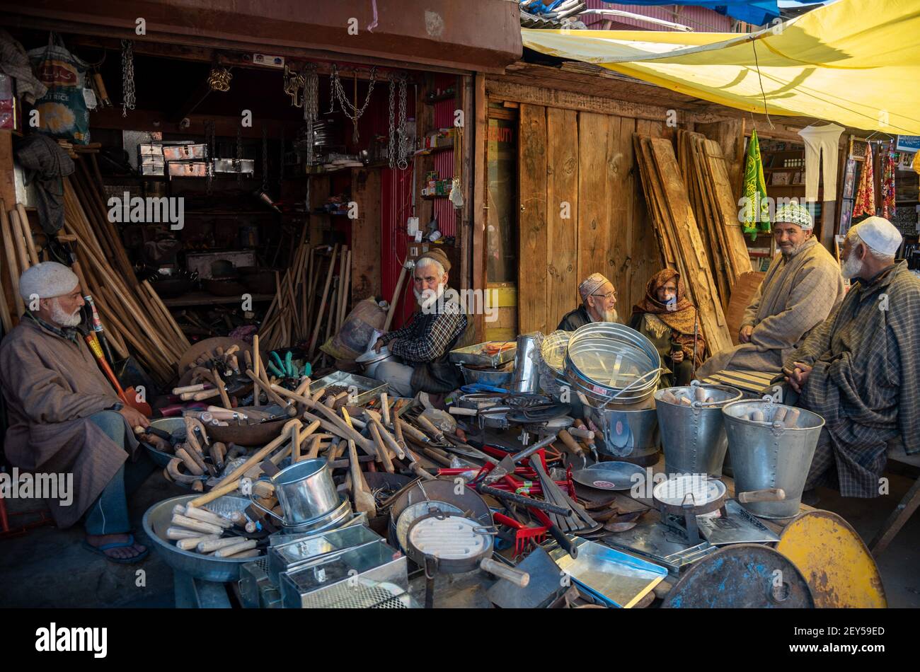 A Kashmiri man sells iron items and wood items at his shop on the bank ...