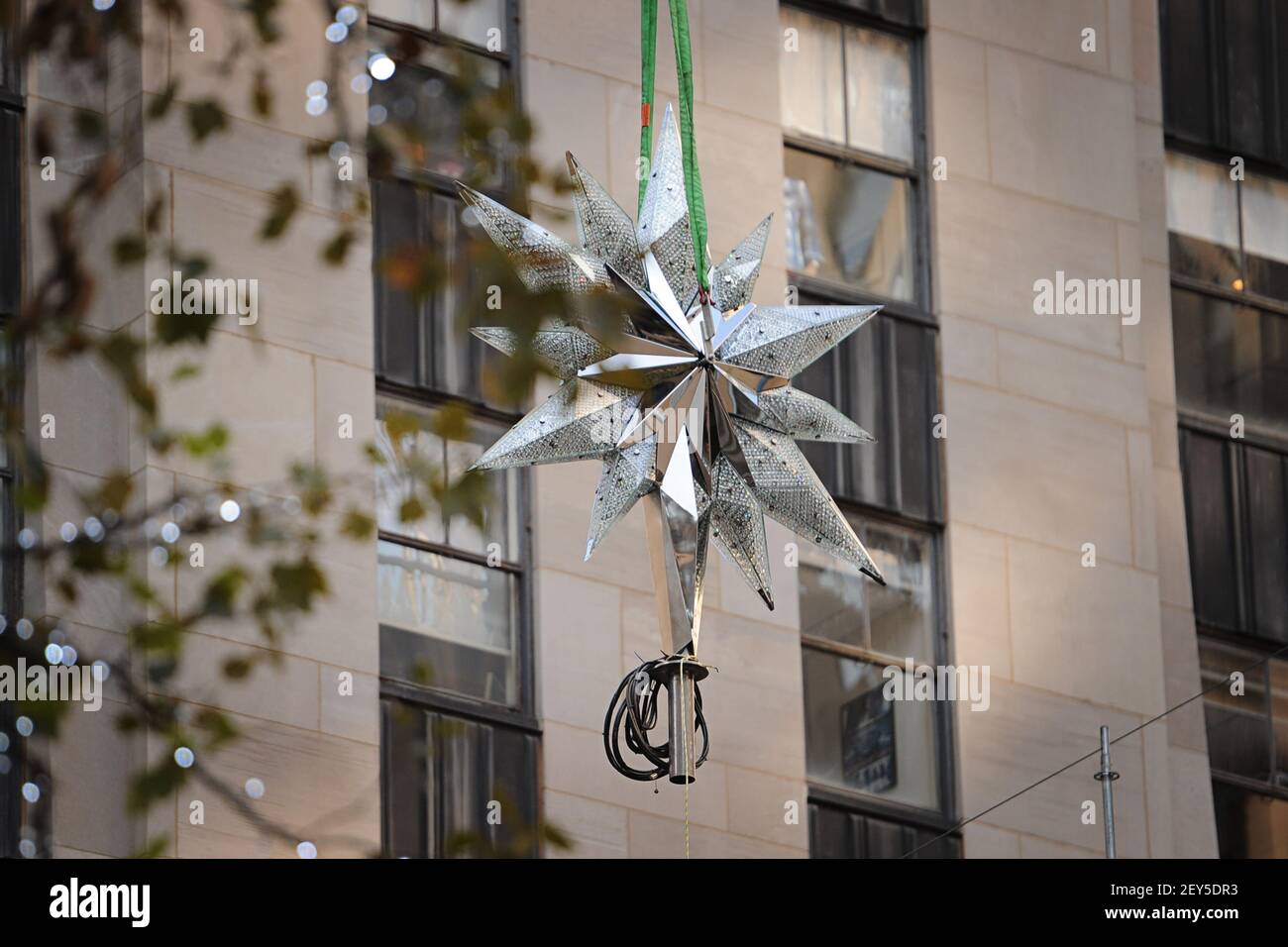 The Swarovski Star is raised by crane as it makes its way to be placed ...