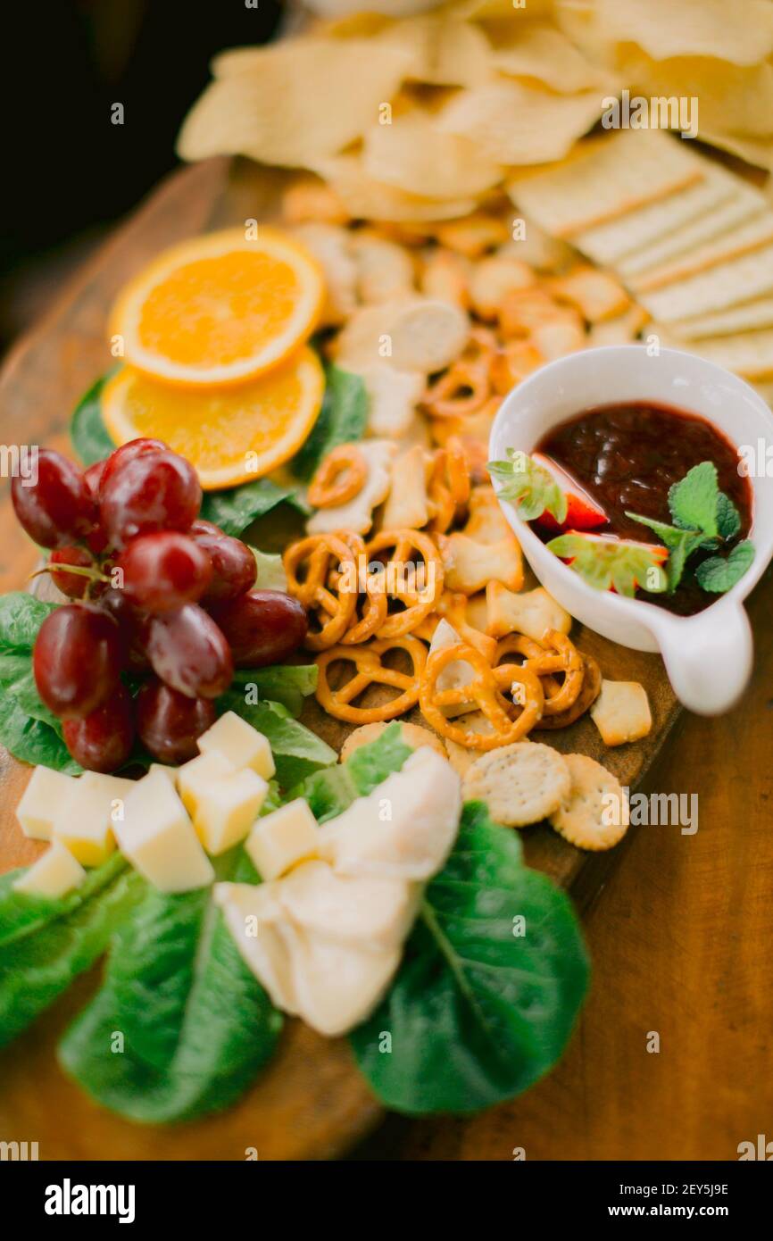 An assortment of yummy snacks: cheese, crackers, chips, fruits, and ...