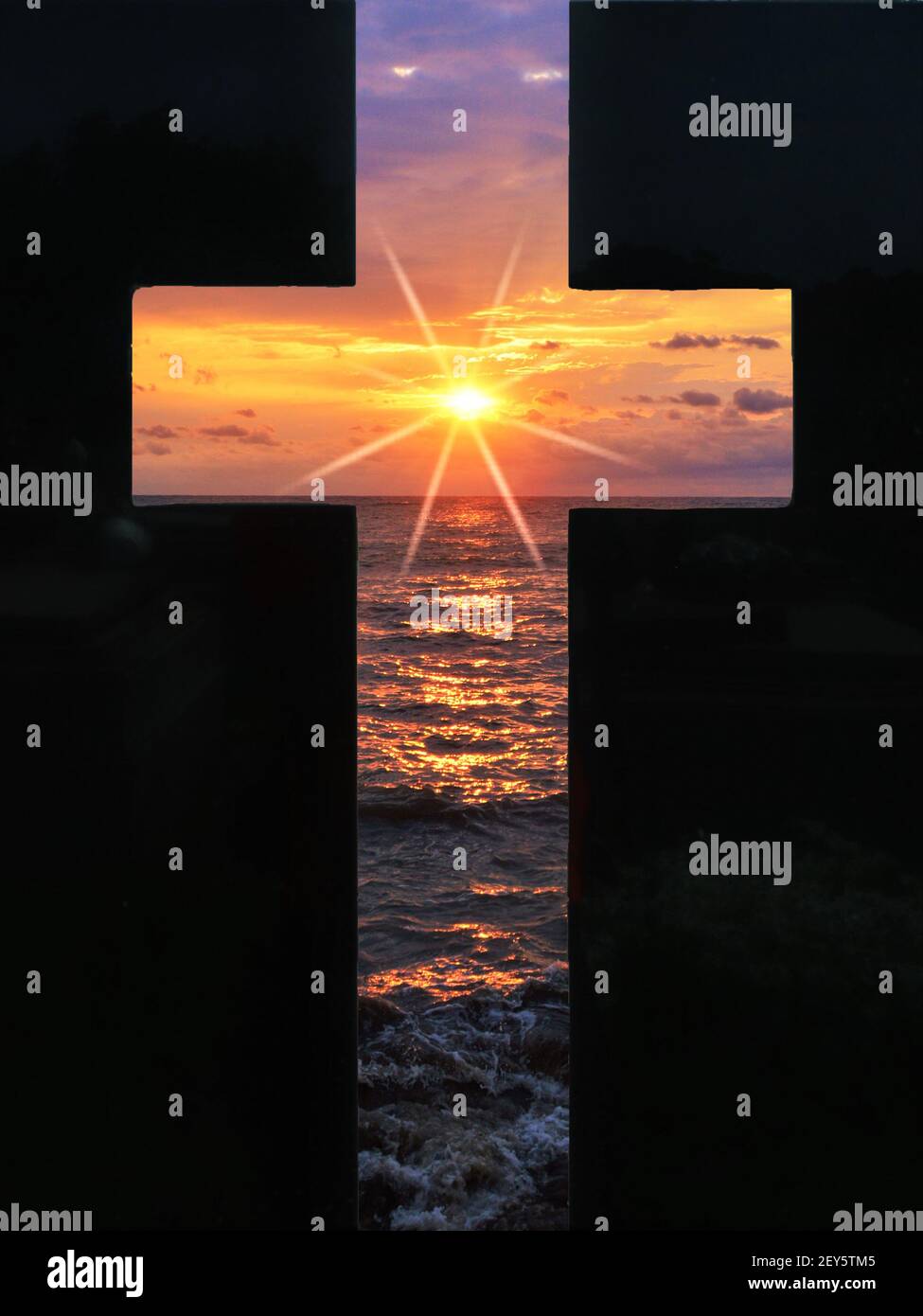 A beautiful sunset and the endless wavey ocean visible through a cross ...