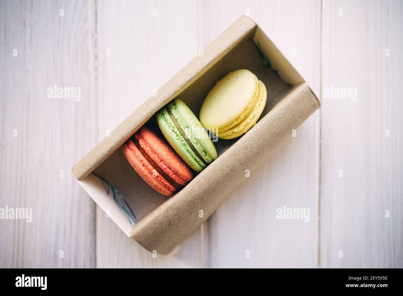 pink, green and yellow macaroni in a box on a white background Stock ...