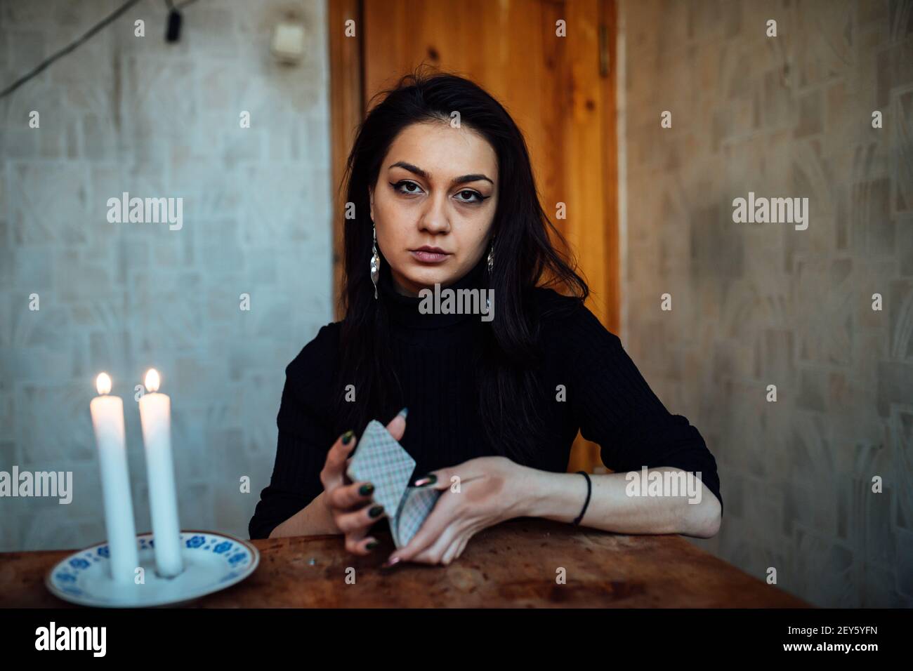 the girl is guessing on a lighted candle and cards, predicting the ...