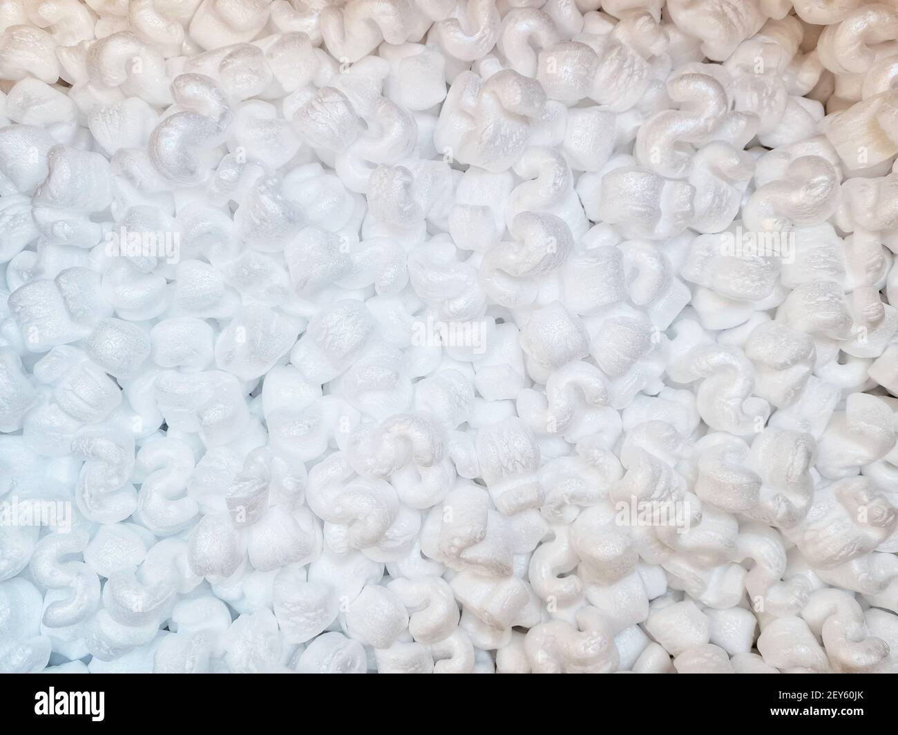 A top view of thousands of s-shaped white shiny polystyrene packaging ...