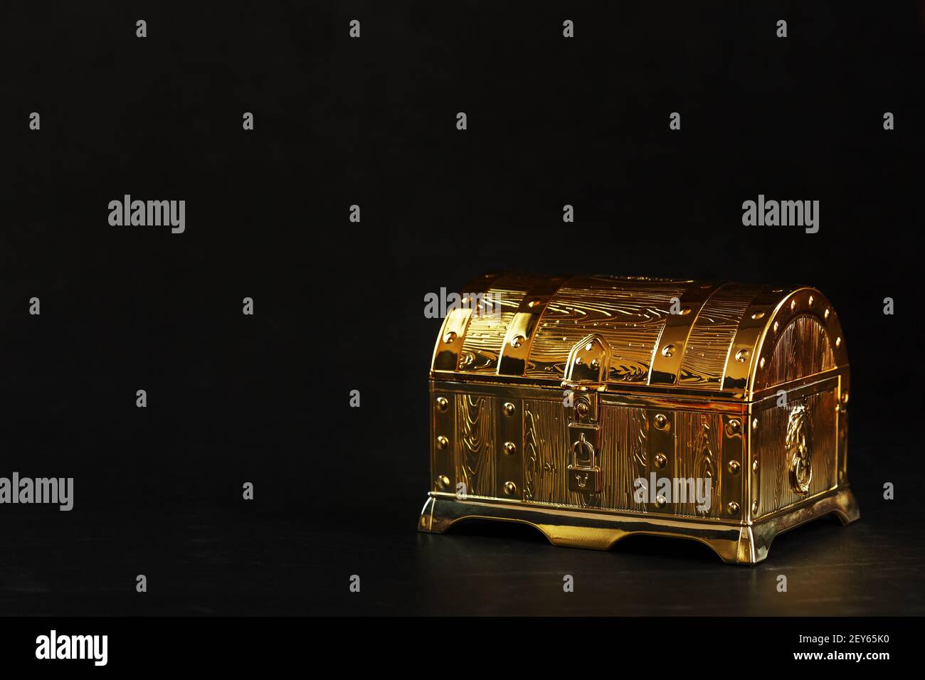 A chest made of gold with jewels on a black background. Free space, the ...