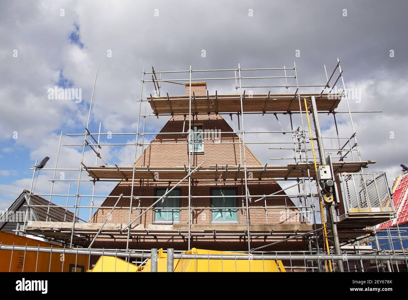 Scaffolding at a house currently under construction. Clouds in the sky ...