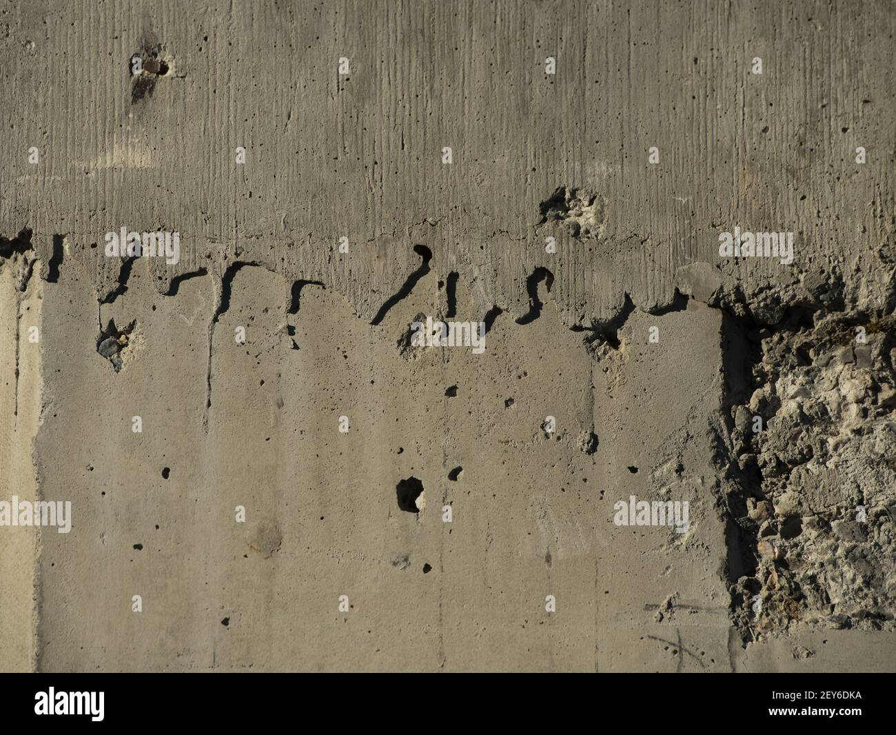 grungy cement exterior wall of industrial building close up pock marks ...