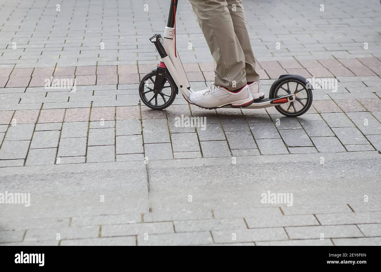 guy riding scooter on granite pavement Stock Photo - Alamy