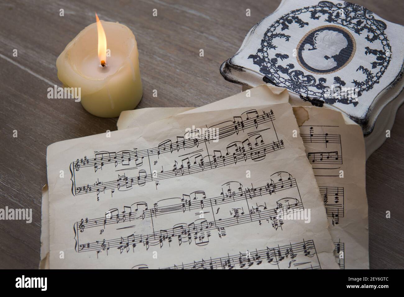music notes on old paper and candles on table Stock Photo - Alamy