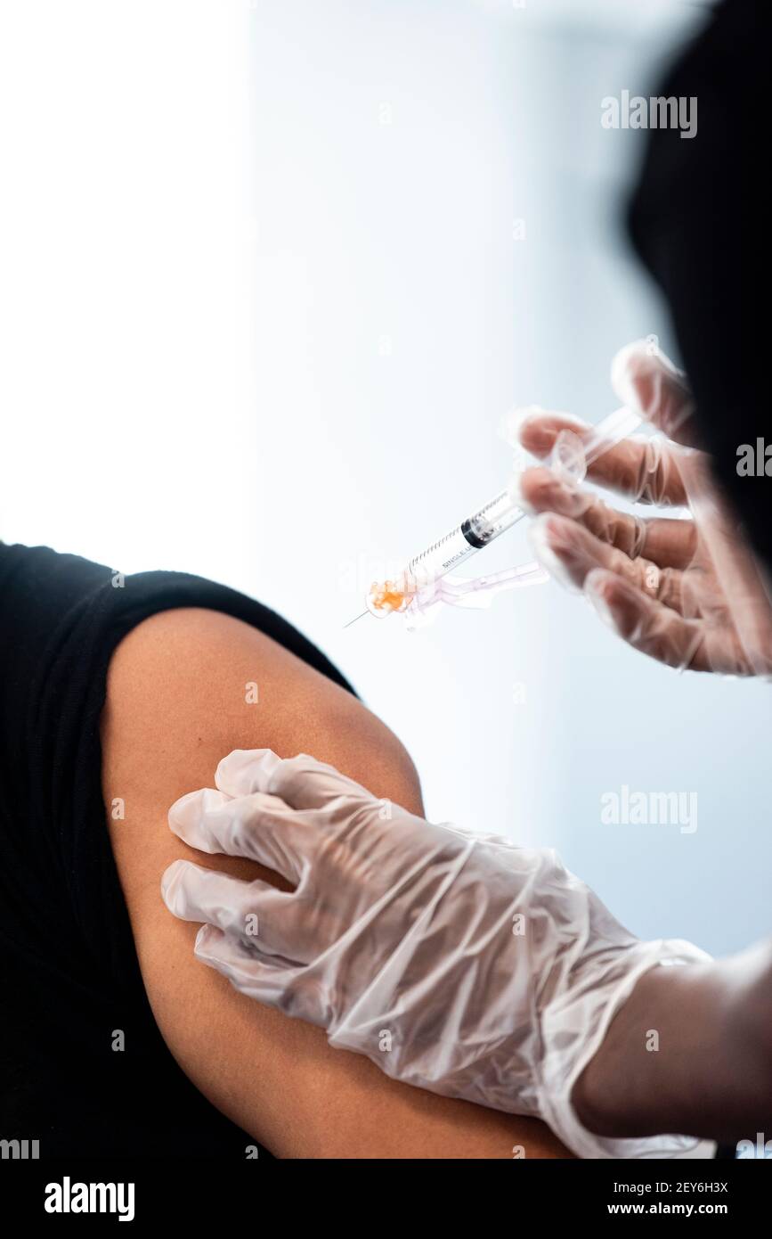 A nurse prepares to give a shot to a patient in a doctor's office Stock ...
