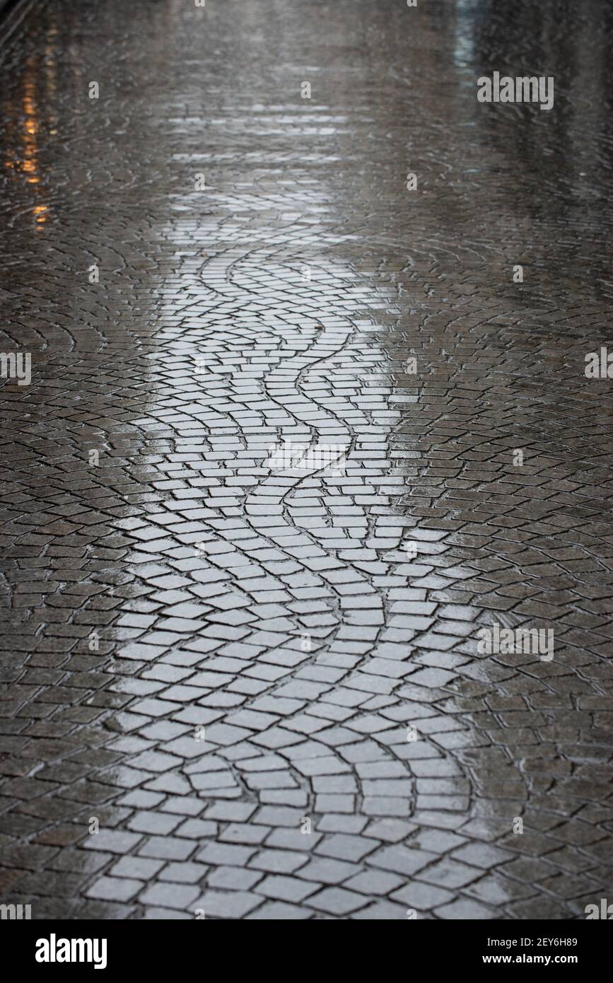 Rain on a cobblestone pavement Stock Photo - Alamy