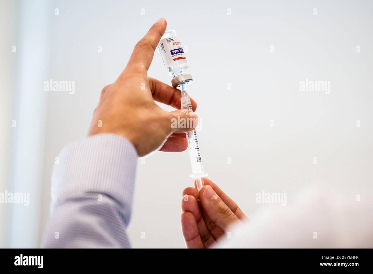 A doctor extracts liquid from a vial in a doctor's office Stock Photo ...