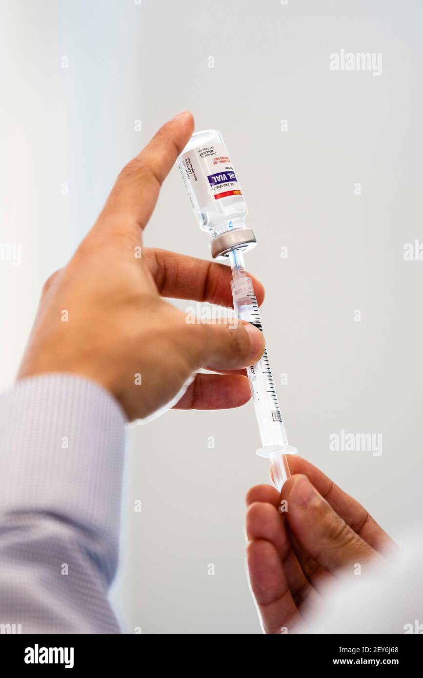 A doctor extracts liquid from a vial in a doctor's office Stock Photo ...