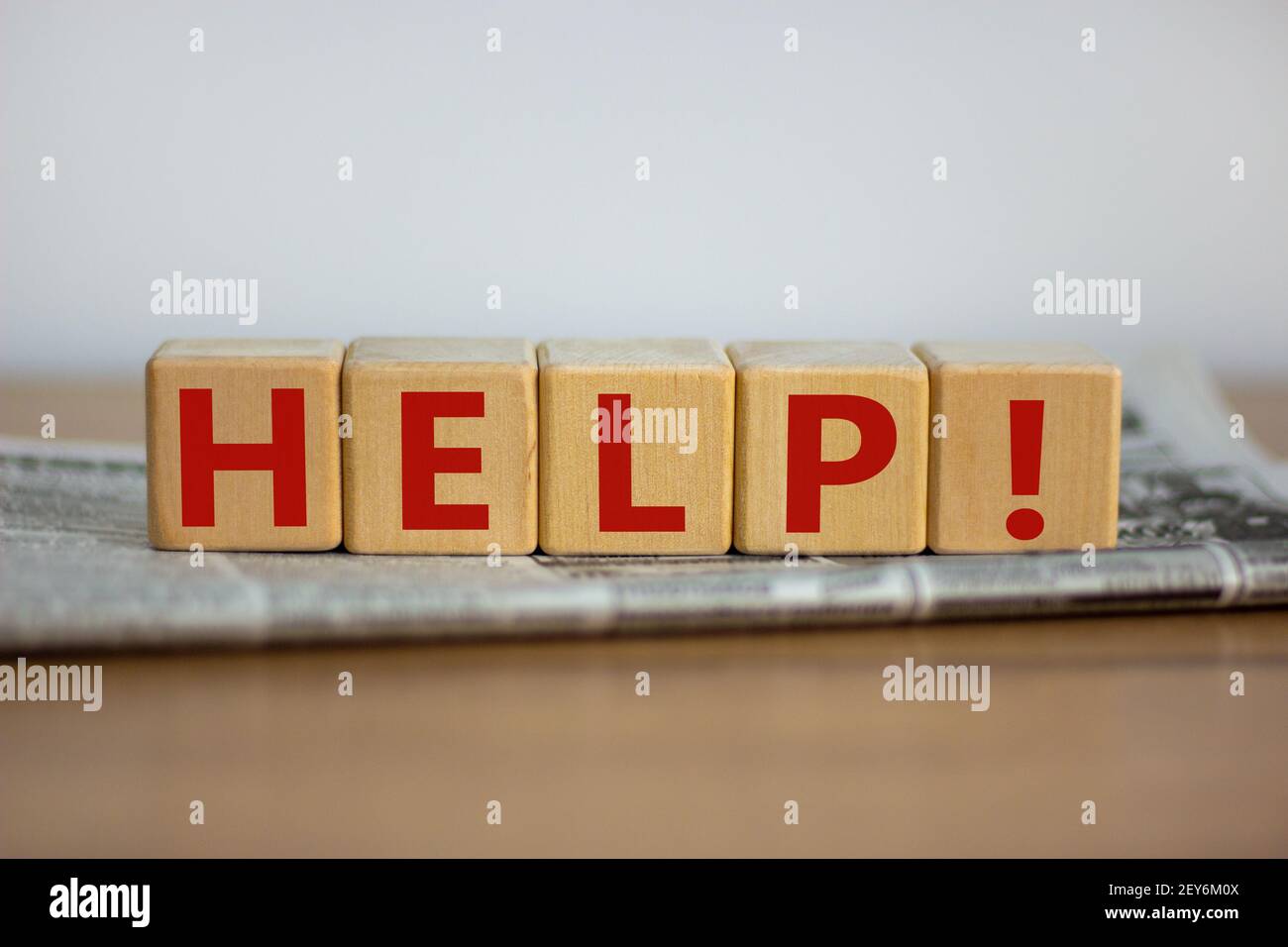 Support and help symbol. Wooden cubes with the word 'help'. Newspaper ...