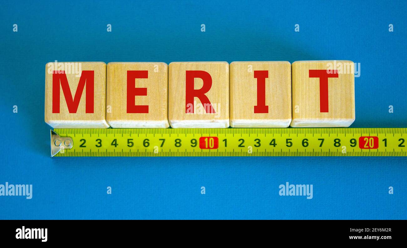 Merit symbol. Wooden cubes with the word 'merit'. Beautiful blue ...
