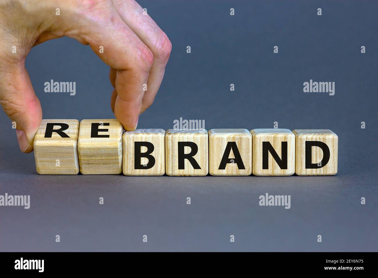 Time to rebrand symbol. Businessman turns wooden cubes and changes the ...